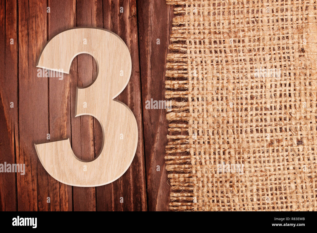 Wooden digit one symbol - 3. On wooden table background wih burlap ...