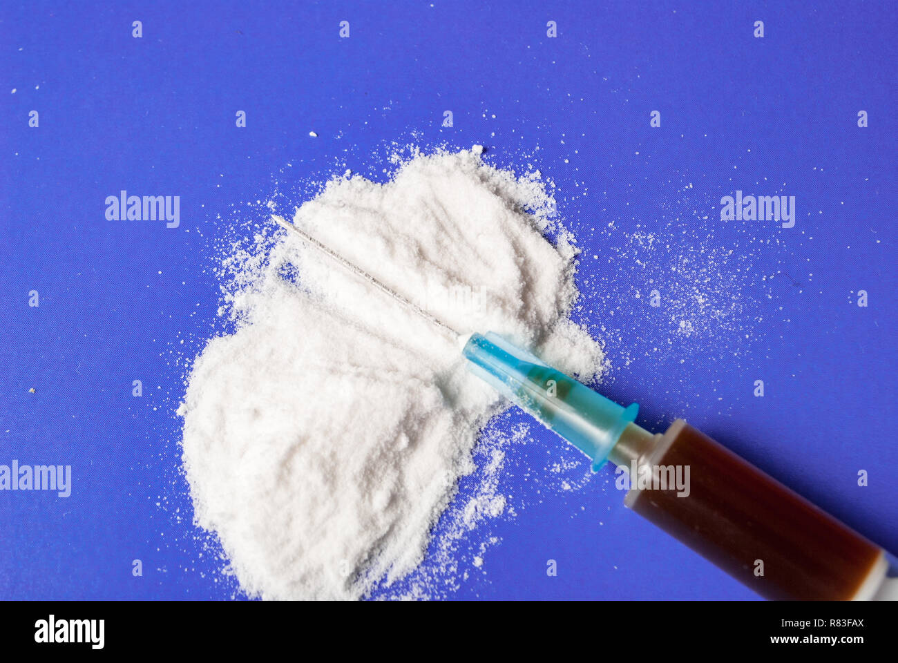 classic transparent syringe cap and needle immersed in white powder ...