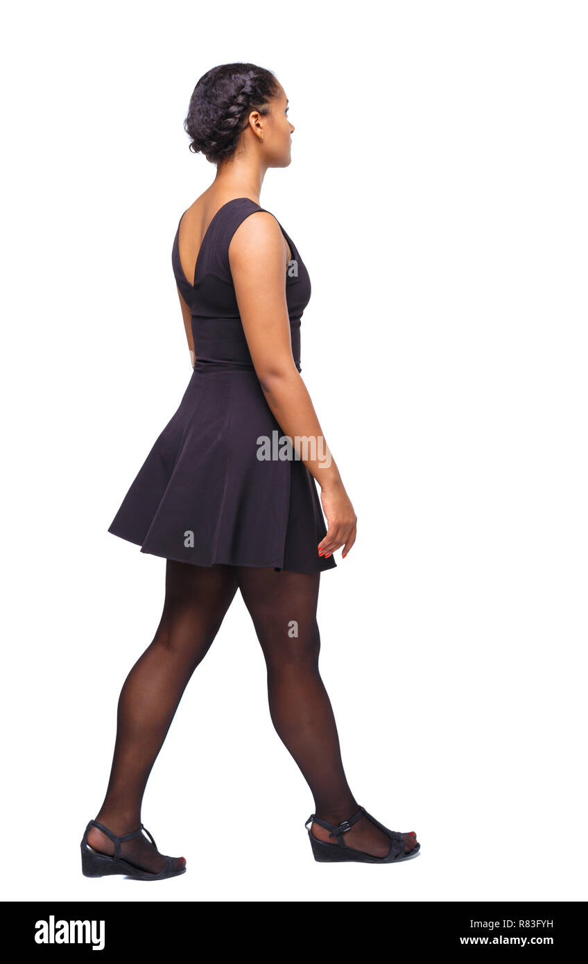 back view of a young black girl walking in jeans and a checkered shirt ...