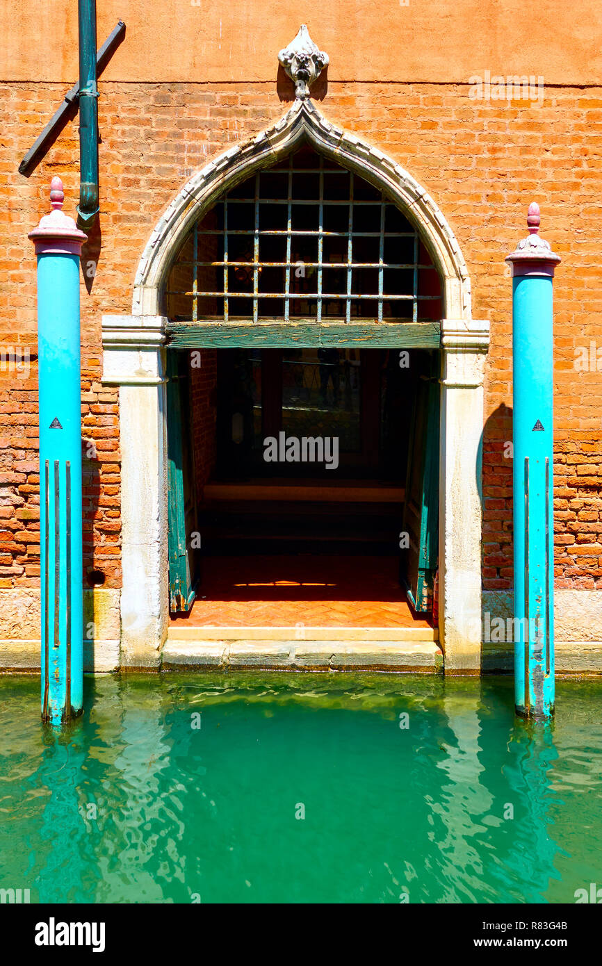 Gate with mooring poles of old venetian house by canal in Venice, Italy ...