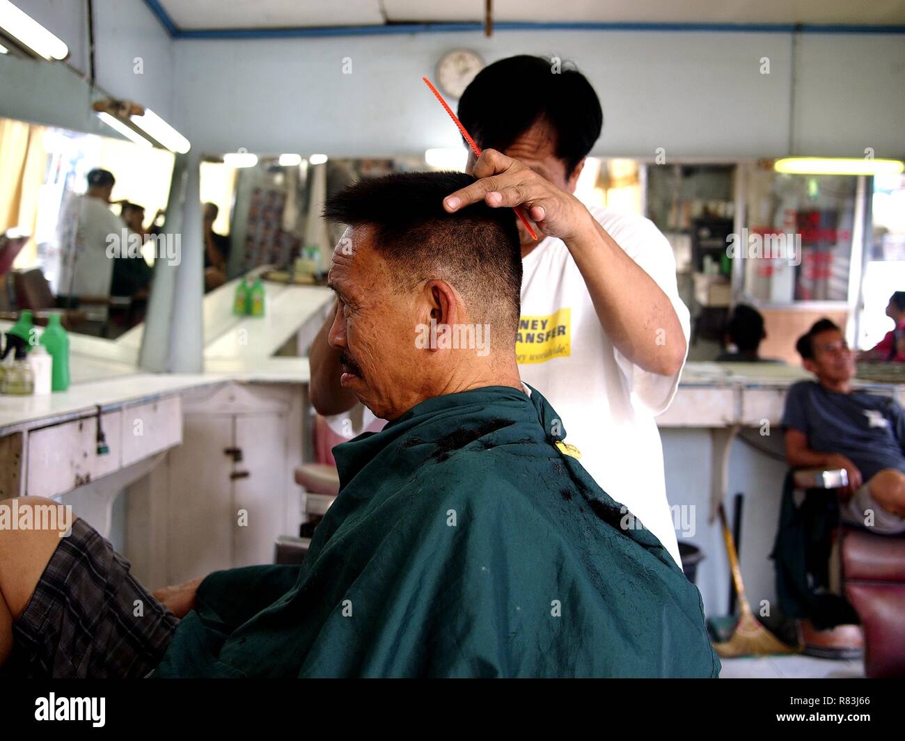 ANTIPOLO CITY, PHILIPPINES - DECEMBER 11, 2018: A barber cuts the hair ...