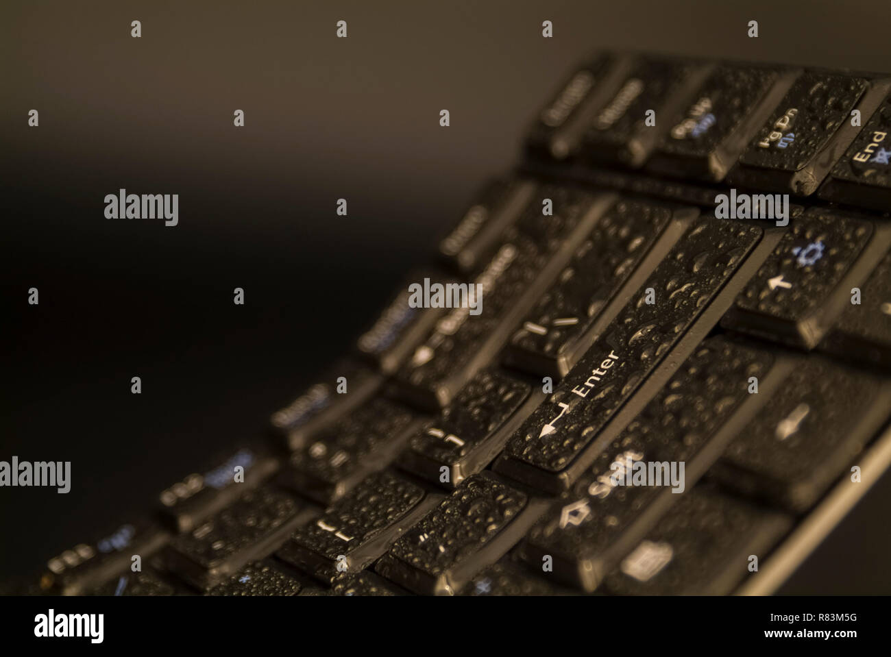 black keyboard with a wet surface focusing on the enter key Stock Photo ...