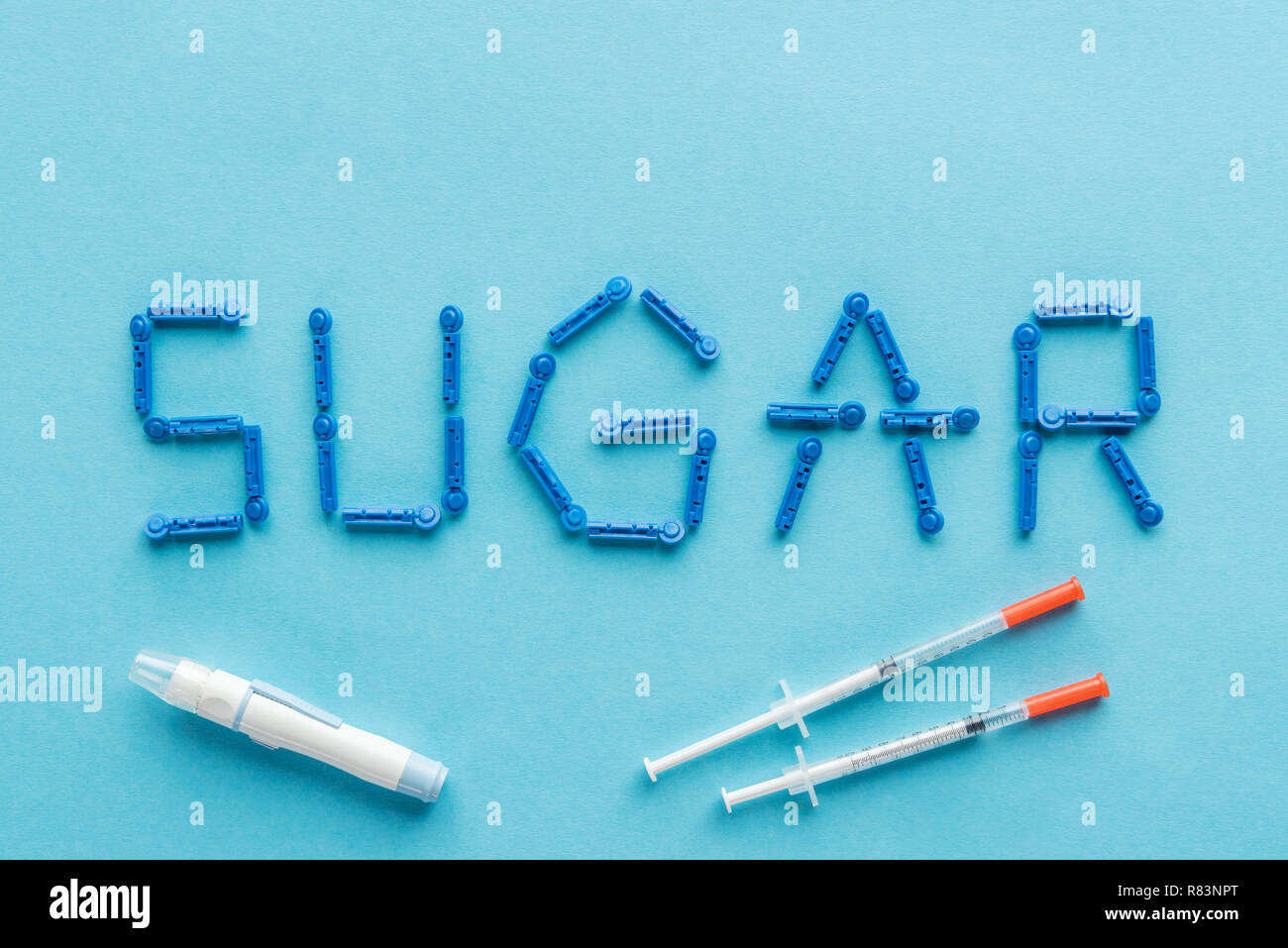 "sugar" word made with disposable needles and insulin syringes on blue ...
