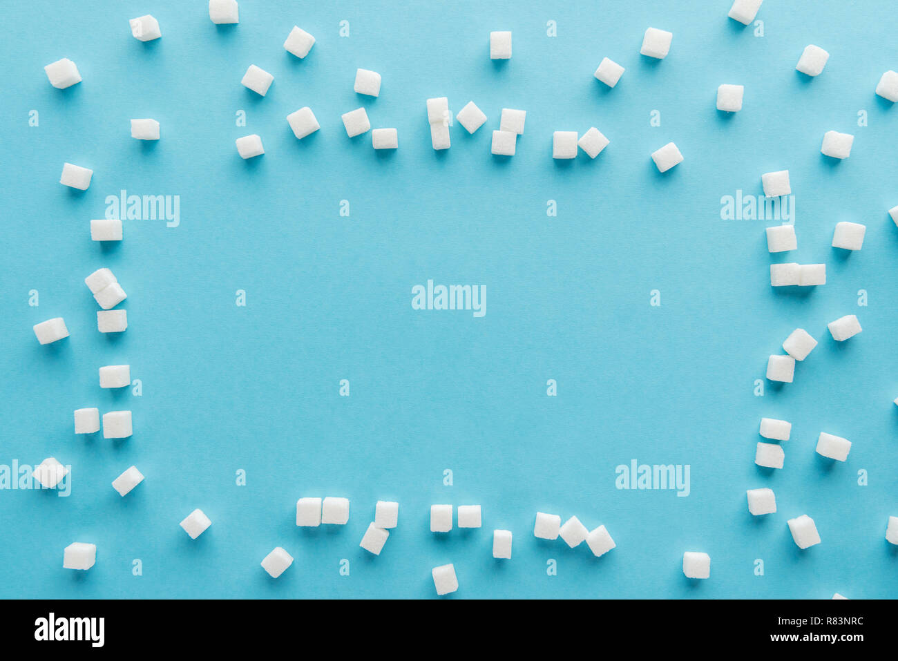top view of frame made with sugar cubes and copy space on blue ...