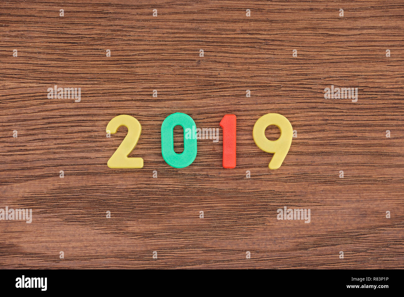 top view of 2019 date made of colorful numbers on wooden background ...