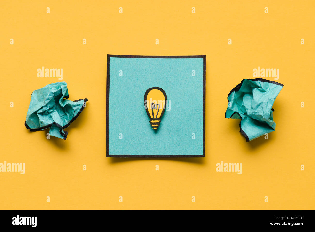 crumpled paper and note with light bulb drawing on yellow background ...