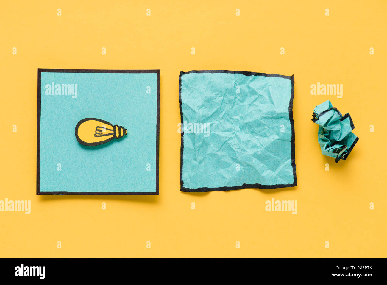 top view of note with light bulb drawing and crumpled paper on yellow ...