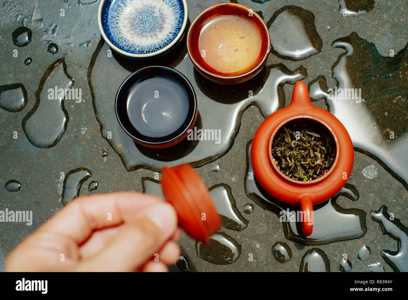 Brewing tea in chinese way (gon fu) with clay pot on surface covered by ...