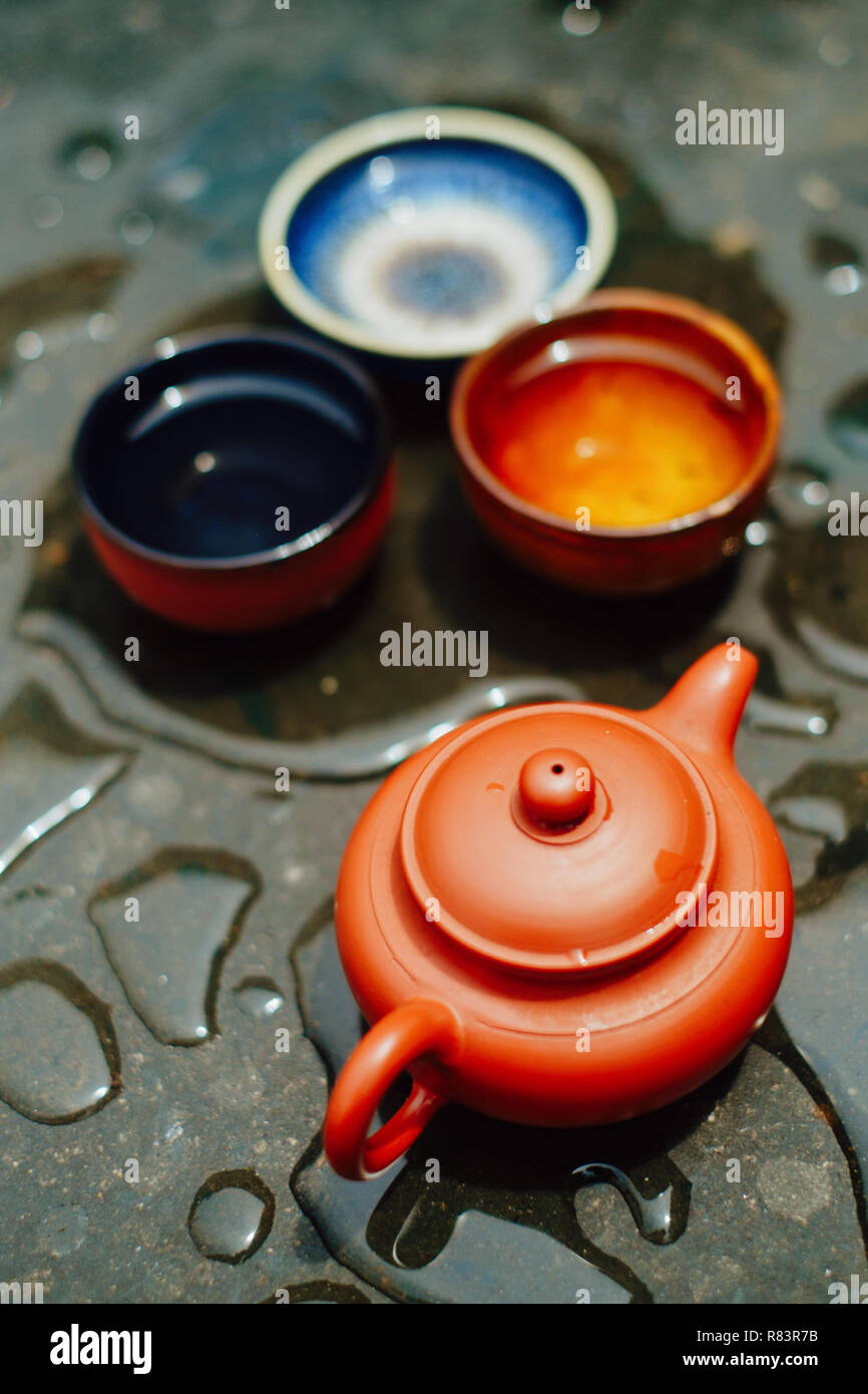 Brewing tea in chinese way (gon fu) with clay pot on surface covered by ...