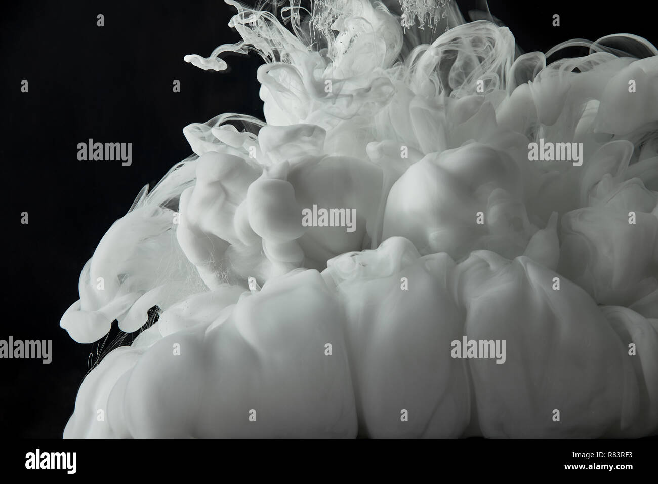 white paint splash in water on black background Stock Photo - Alamy