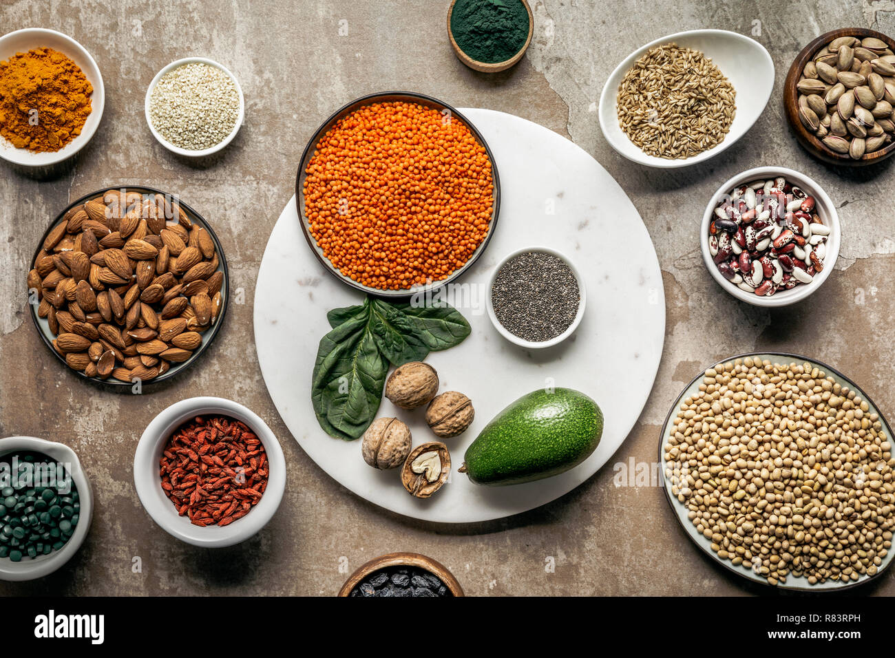flat lay of superfoods, legumes, nuts and avocado on textured rustic ...