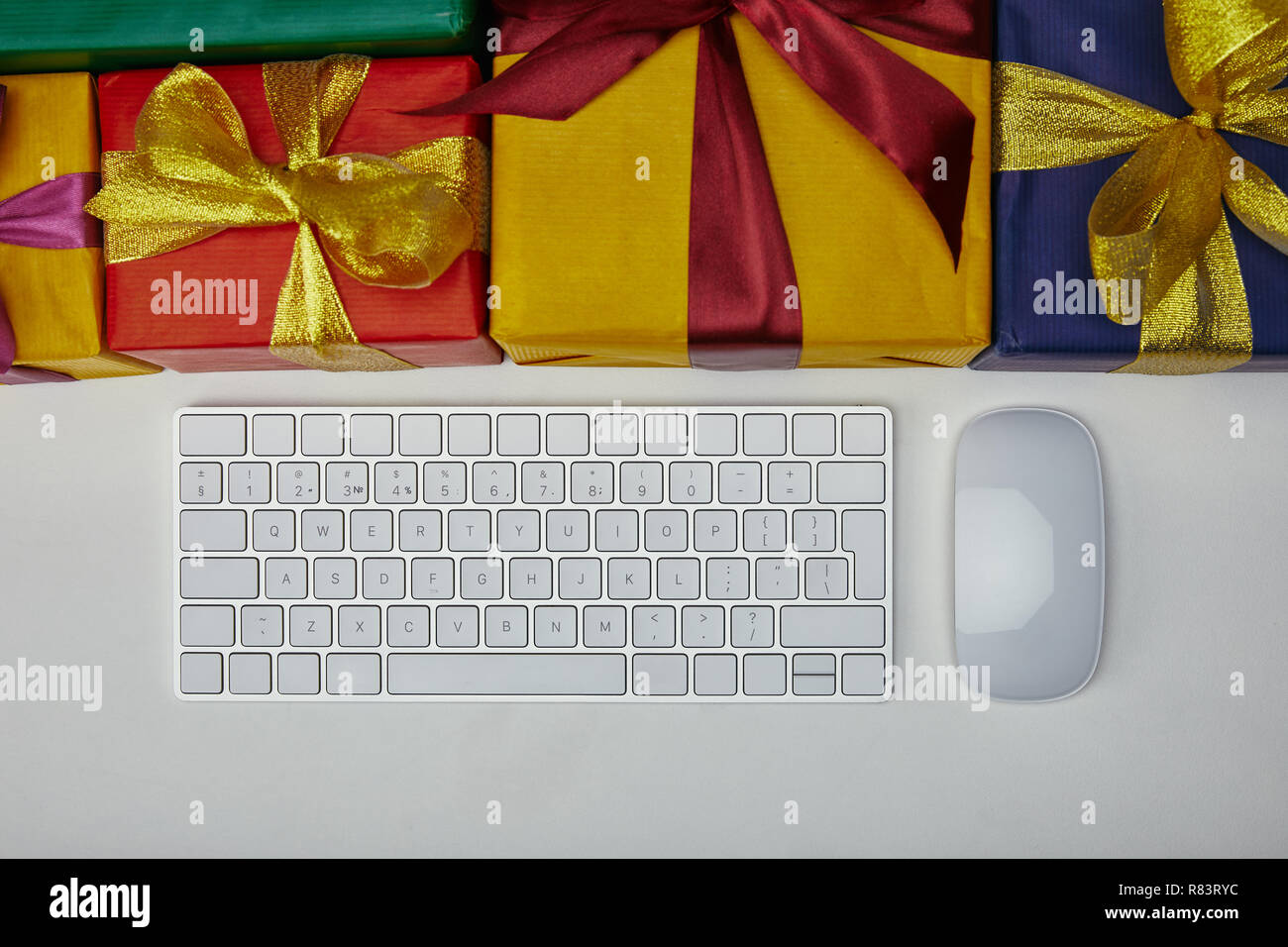 Top view of gifts near computer keyboard and computer mouse on white ...