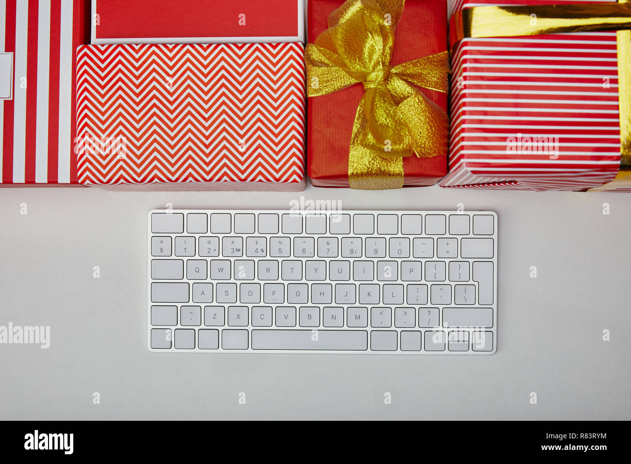 Top view of colorful presents near white computer keyboard on white ...