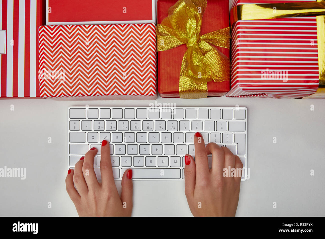 Top view of woman typing on white computer keyboard near colourful ...