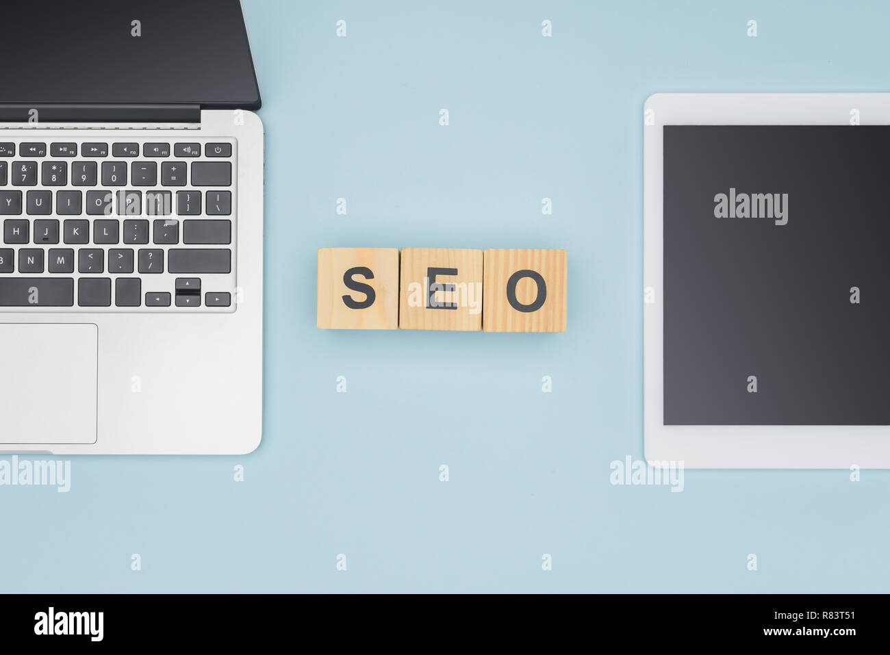 Top view of gadgets near wooden blocks on light blue background Stock ...