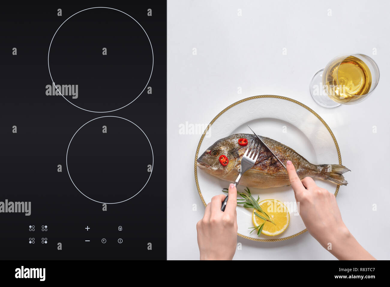 partial top view of person eating gourmet fried fish with cherry ...