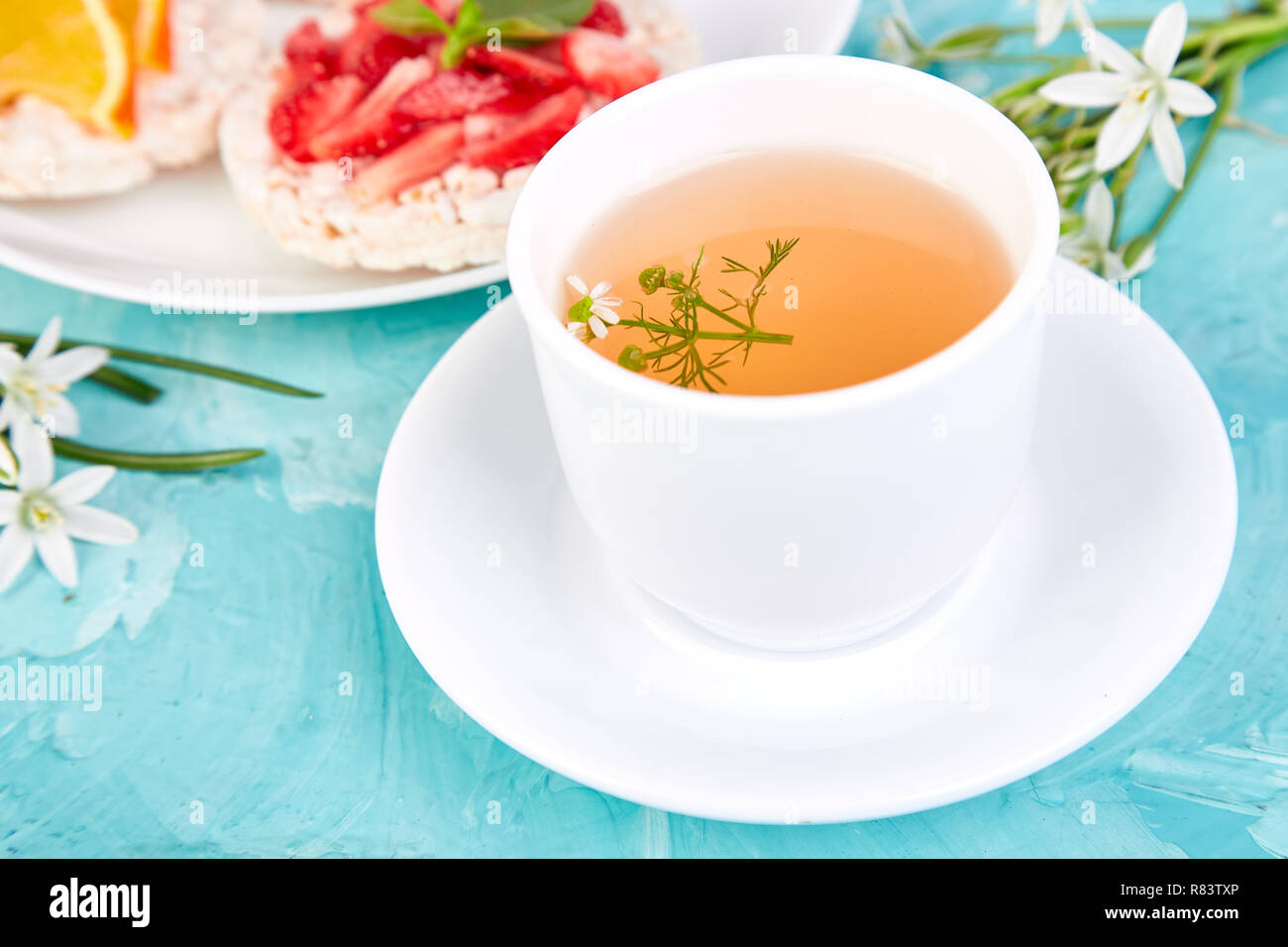 Breakfast - tea, rice crispbread with fresh fruits on blue background ...