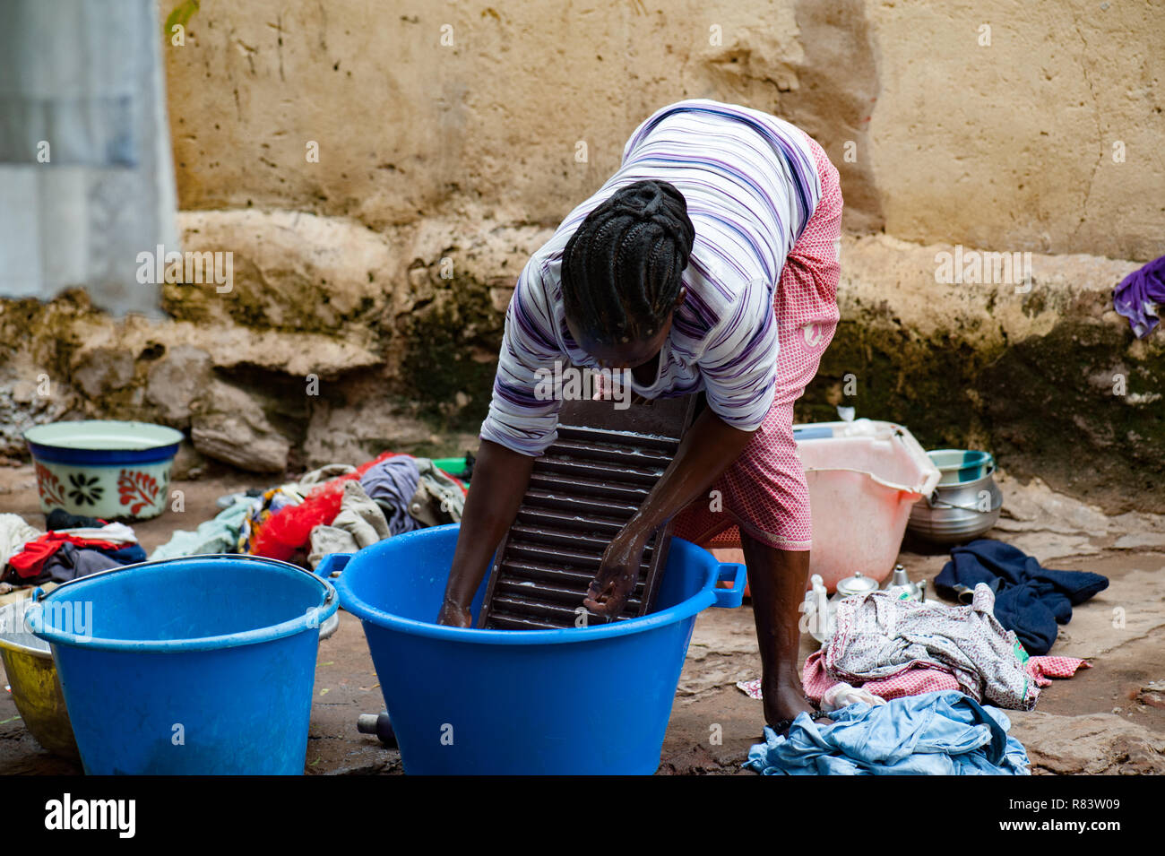 Mali,Africa - Black african young woman washing family dressed with ...