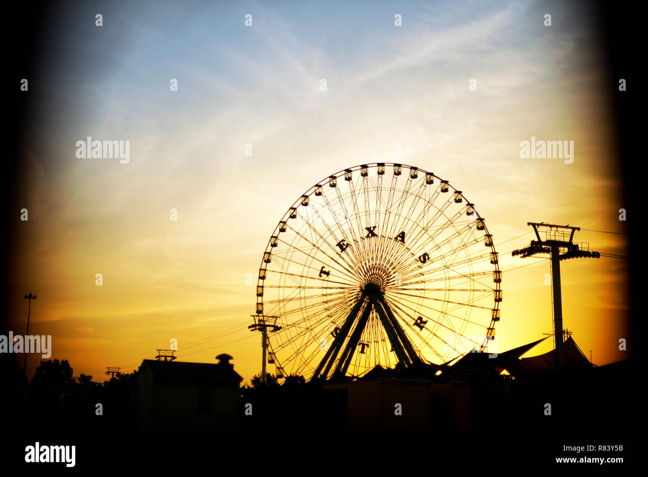 Sun setting over a ferris wheel Stock Photo - Alamy