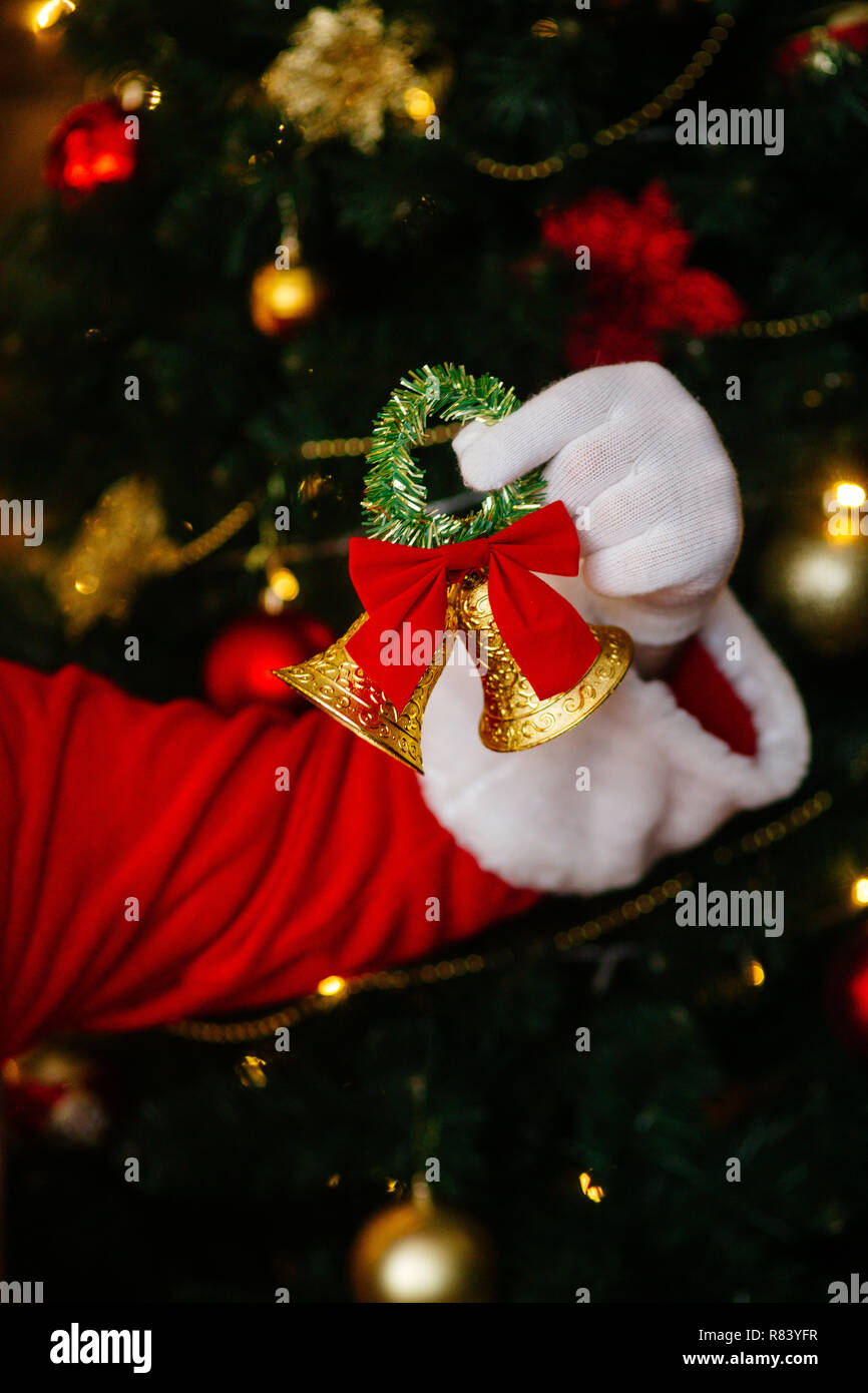 Santa Claus ringing a bell near Christmas tree Stock Photo - Alamy