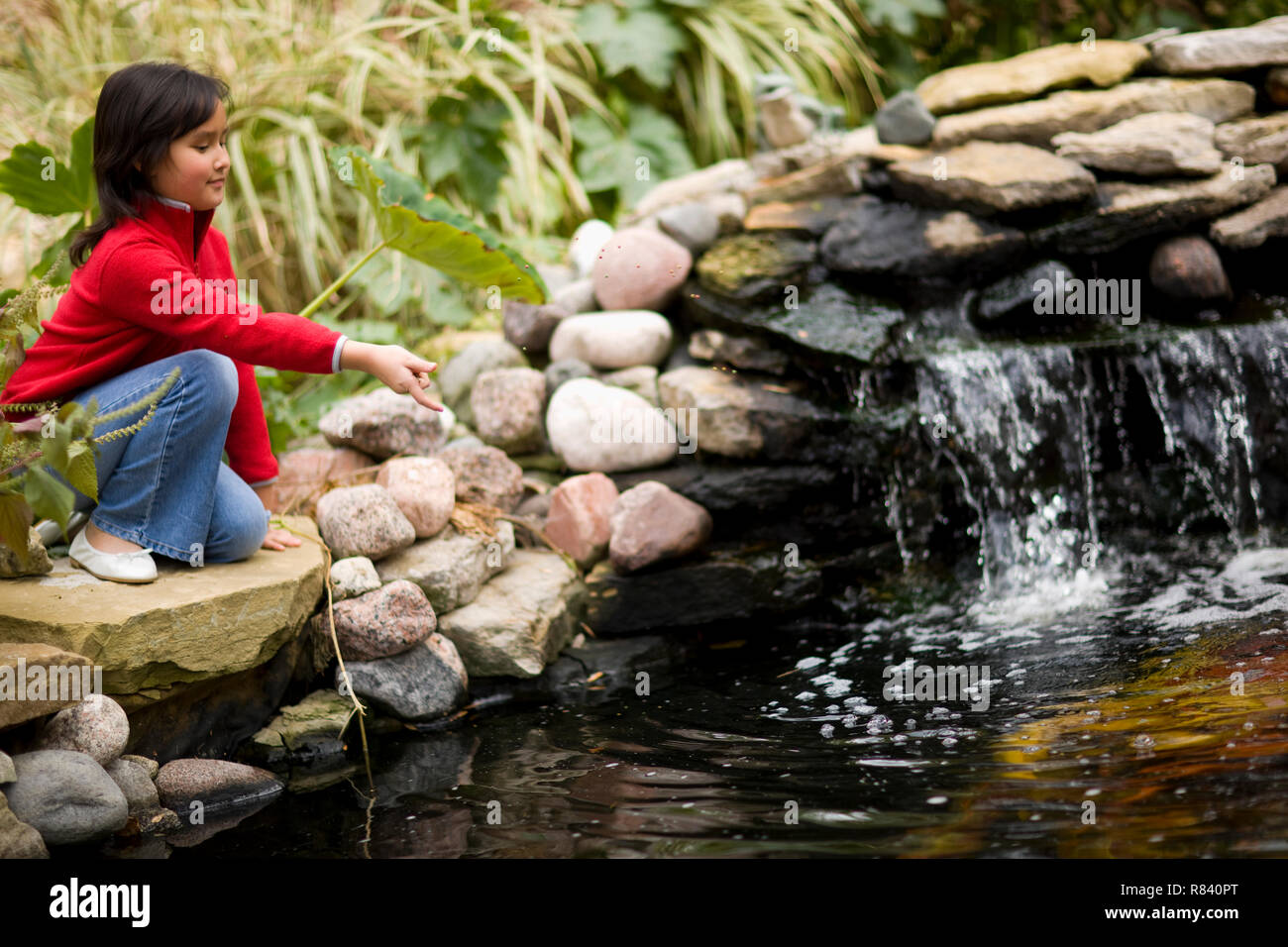 Young girl throwing stone into river Stock Photo - Alamy