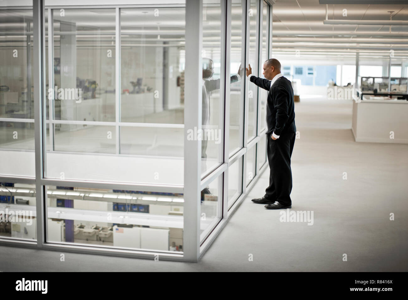 Businessman looking down to an atrium in his office Stock Photo - Alamy