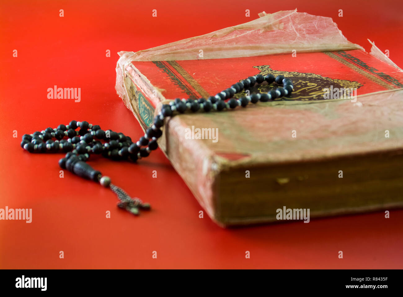 A closed Koran with prayer beads on it Stock Photo - Alamy