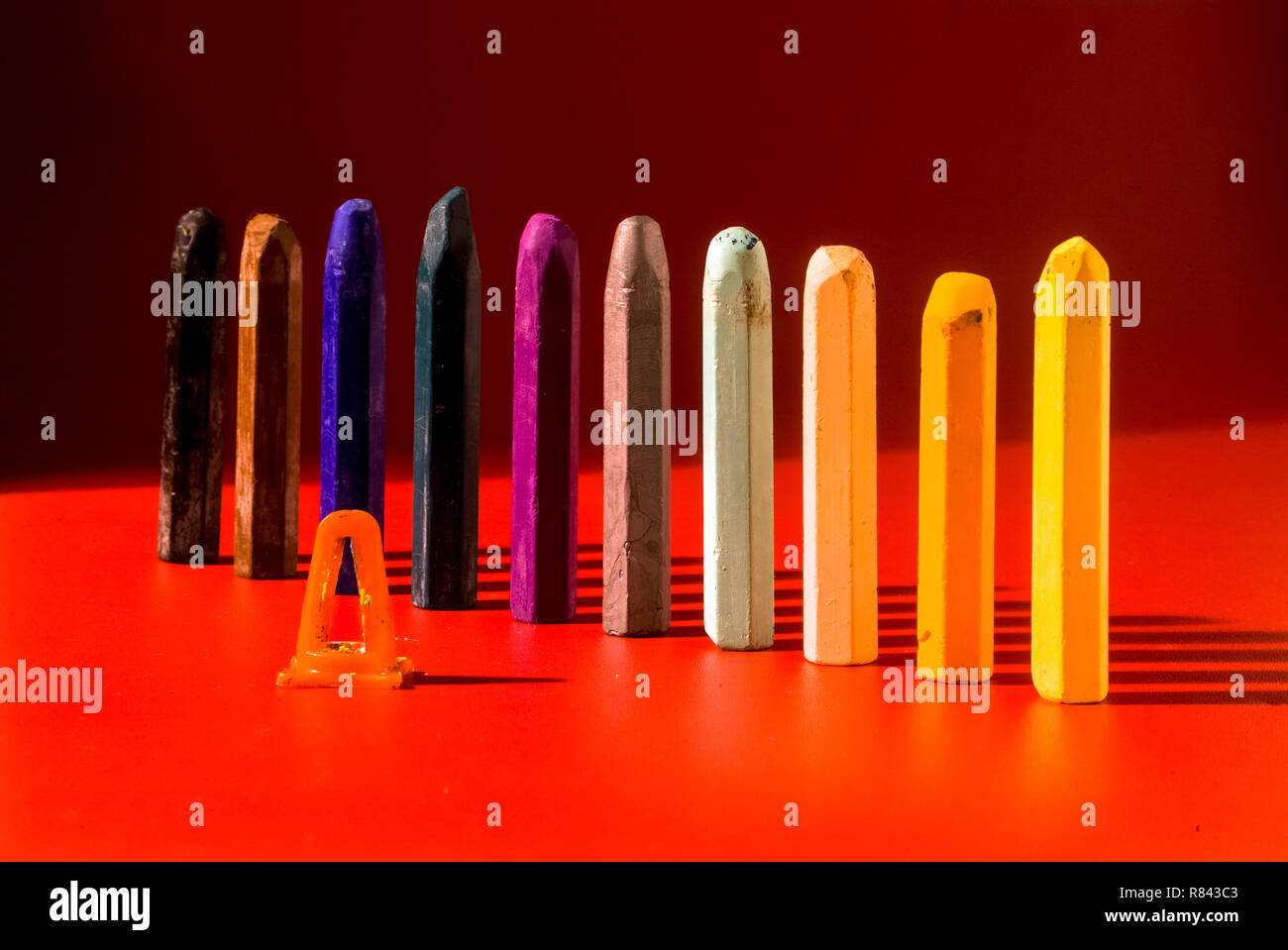 colorful crayons are set up in a line and cause shadows to line up ...