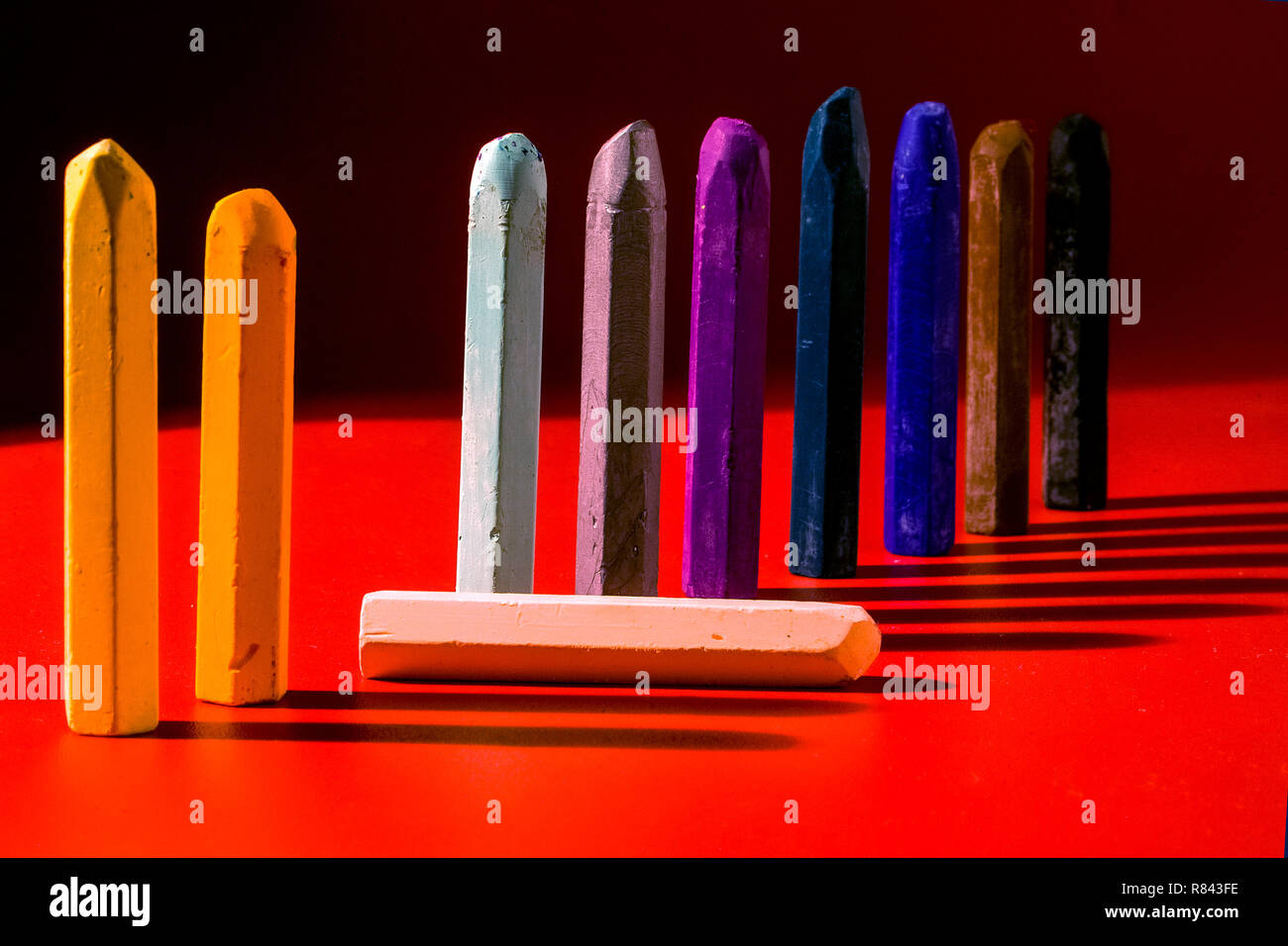 colorful crayons are set up in a line and cause shadows to line up ...