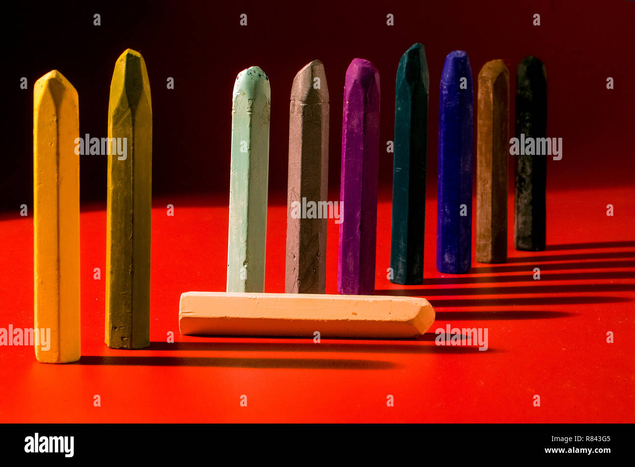 colorful crayons are set up in a line and cause shadows to line up ...