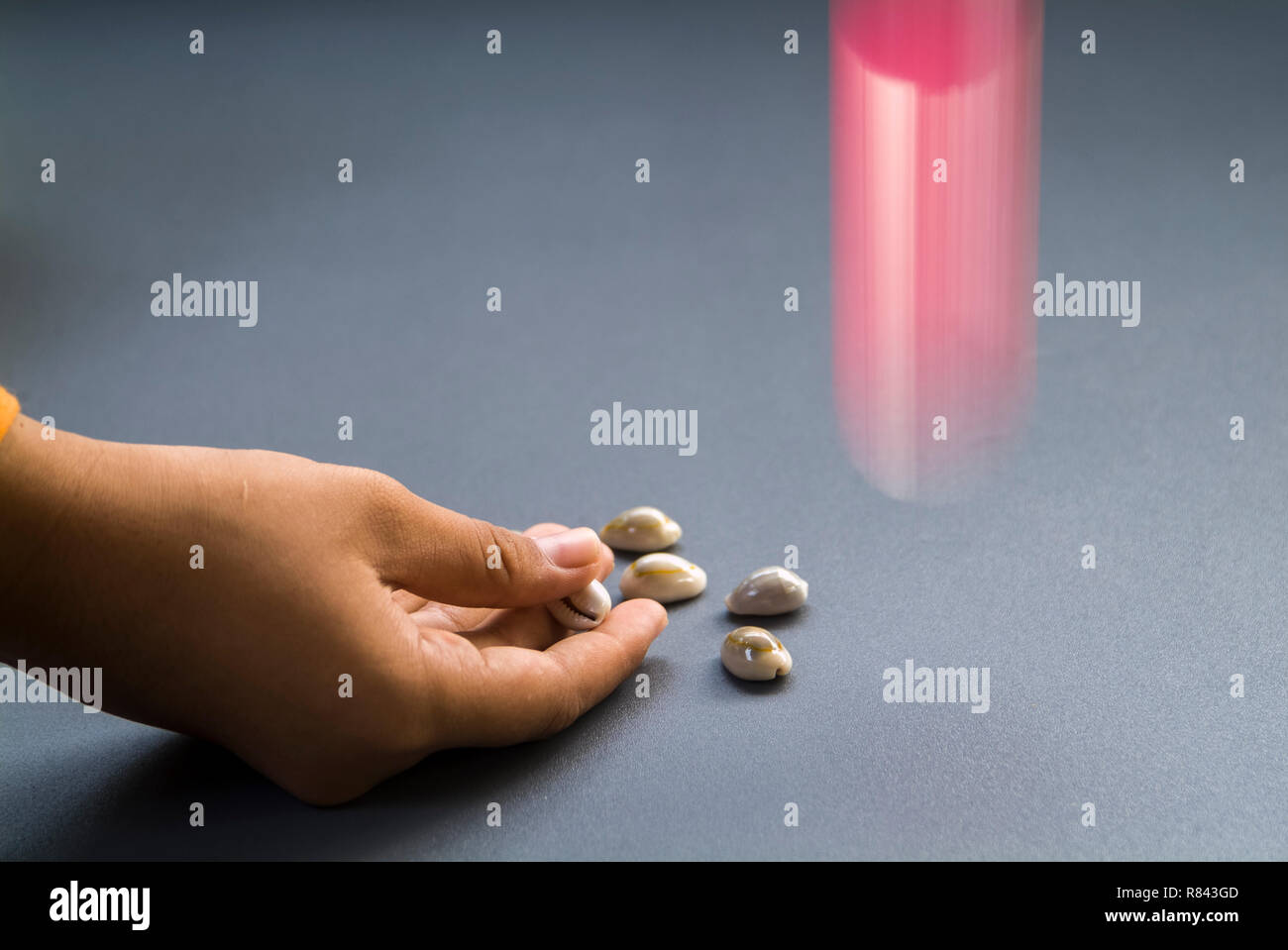 hand of a girl prepares to throw balls in traditional bekel ball games ...