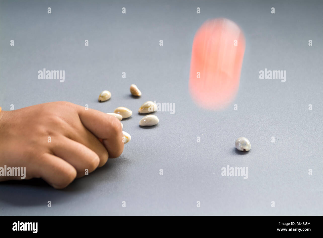 hand of a girl prepares to throw balls in traditional bekel ball games ...