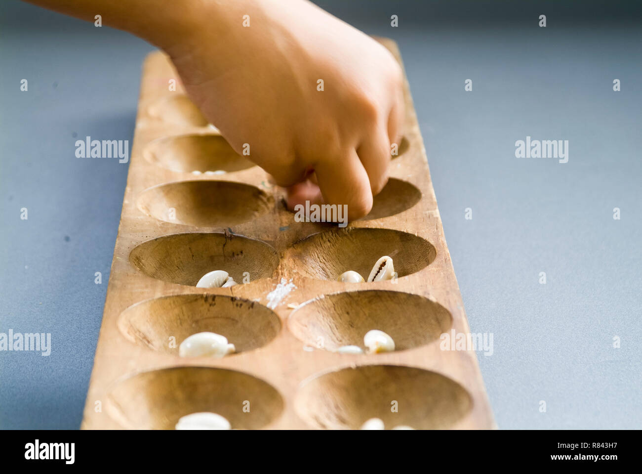 the hand of girl is playing Indonesian traditional mancala games Stock ...