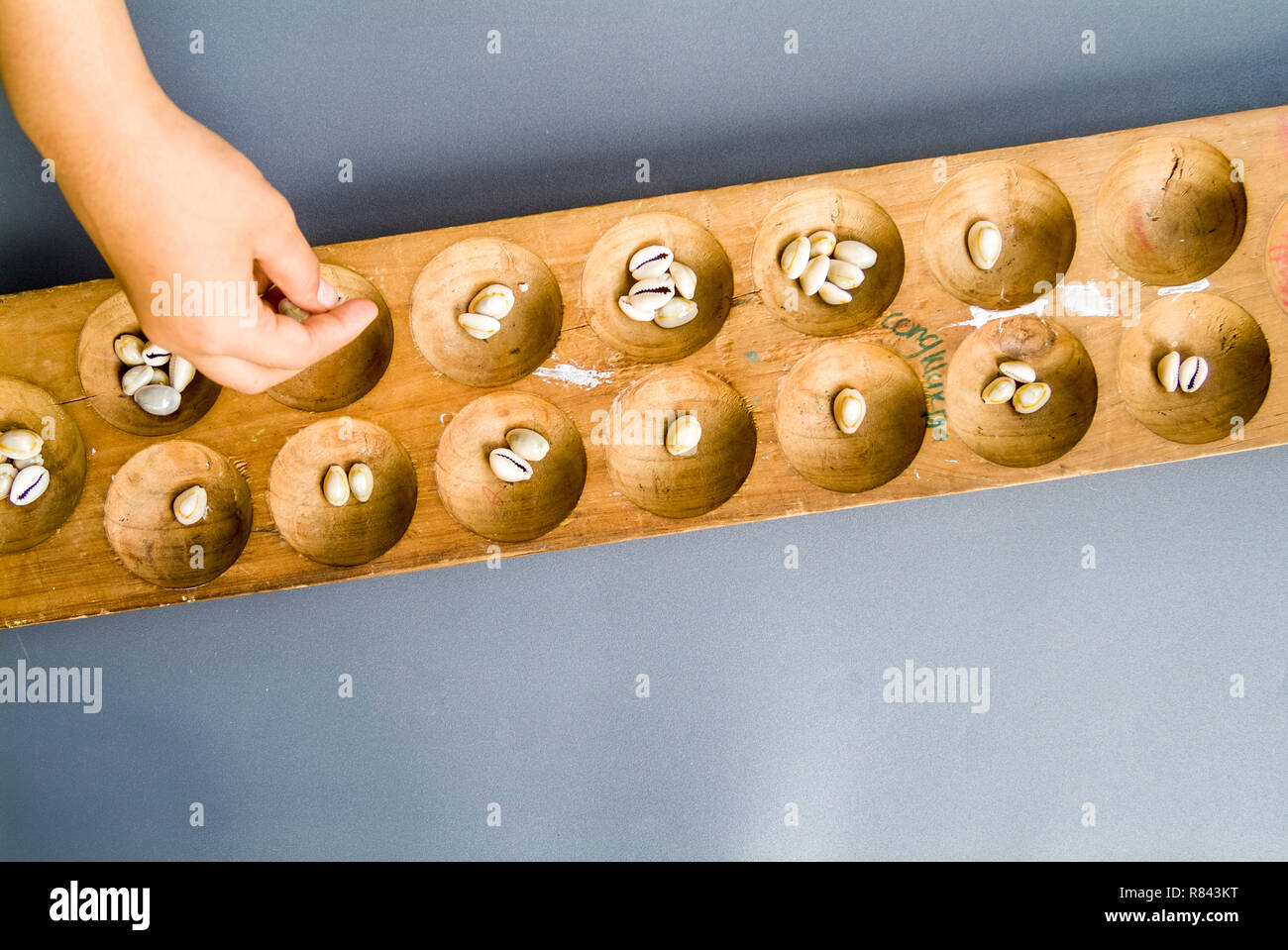 the hand of girl is playing Indonesian traditional mancala games Stock ...