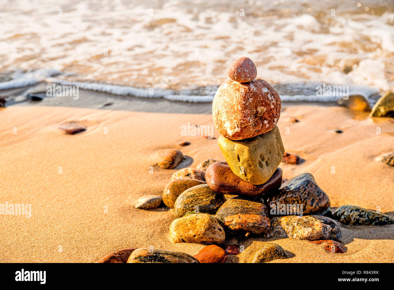 Zen stone pyramid at a beach with surf Stock Photo - Alamy