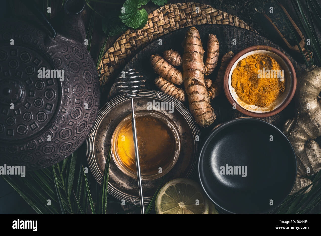 Top view of dark tea set with honey and turmeric root and powder ...