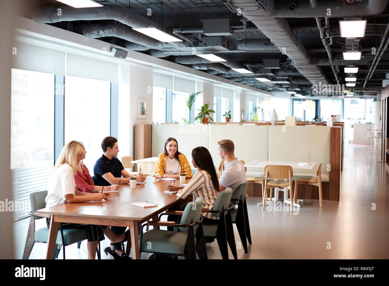 Group Of Young Candidates Sitting Around Table And Collaborating On ...
