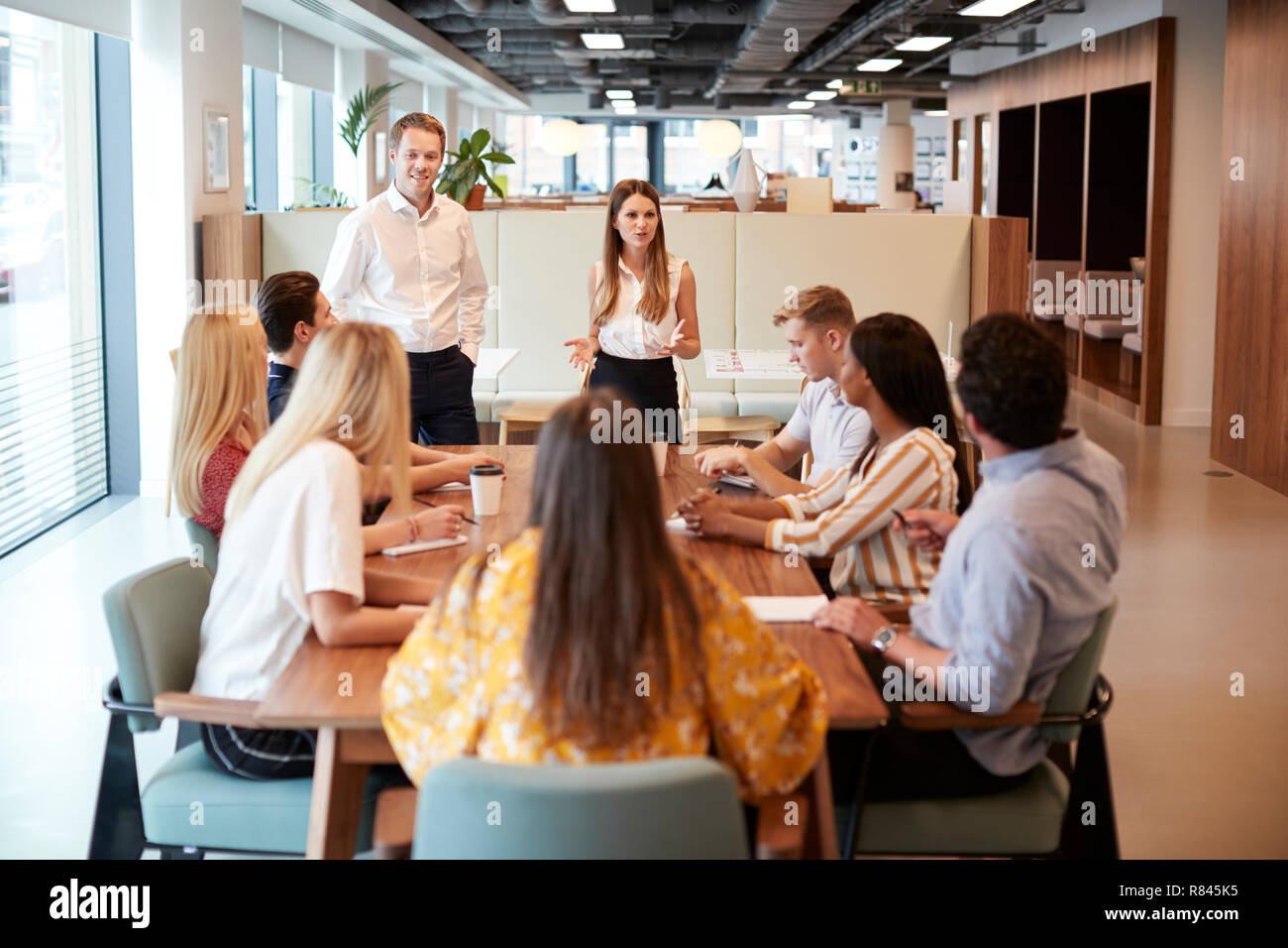 Businessman And Businesswoman Addressing Group Of Young Candidates ...