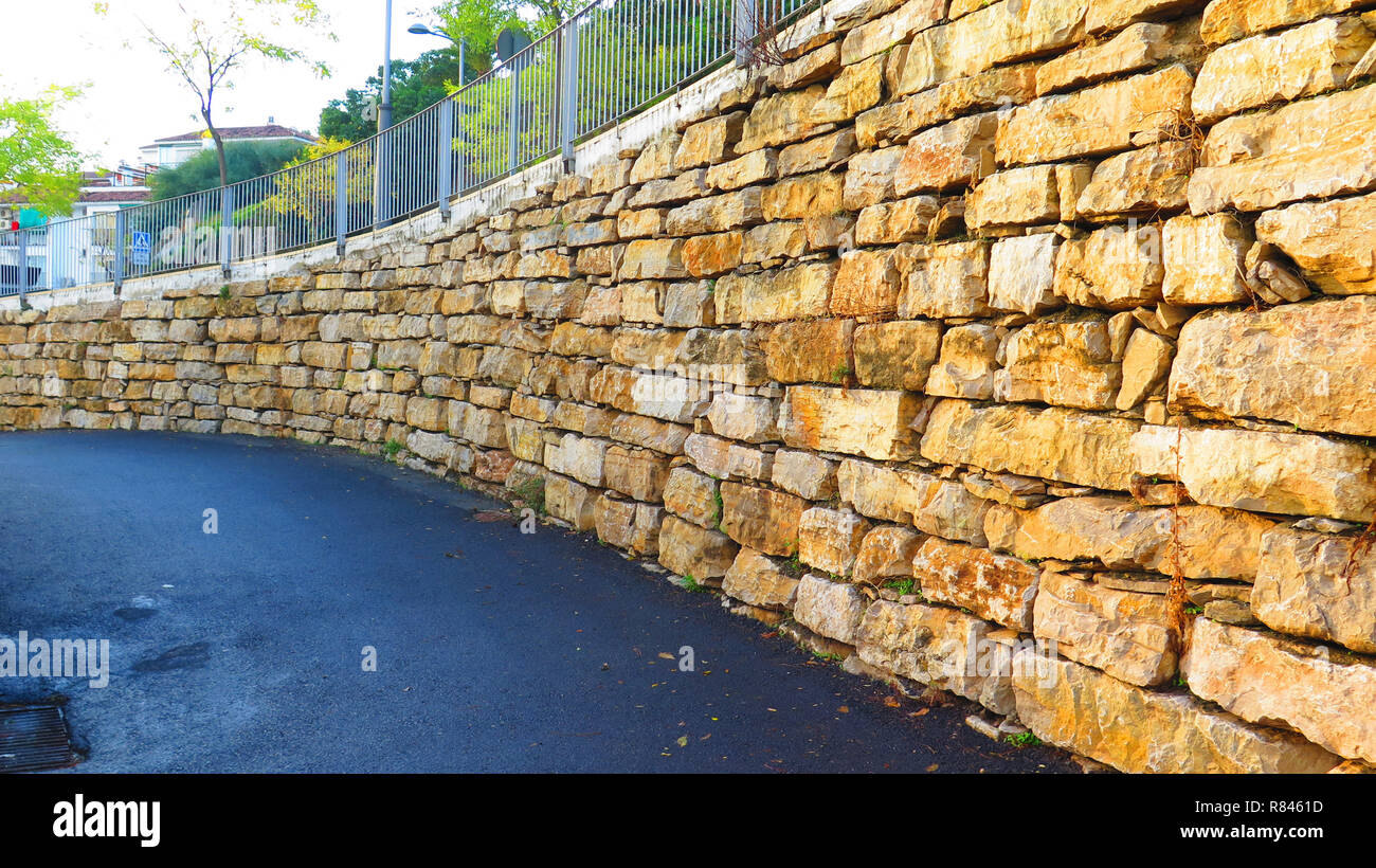 Retaining wall from granite blocks in residential street in Andalusian ...