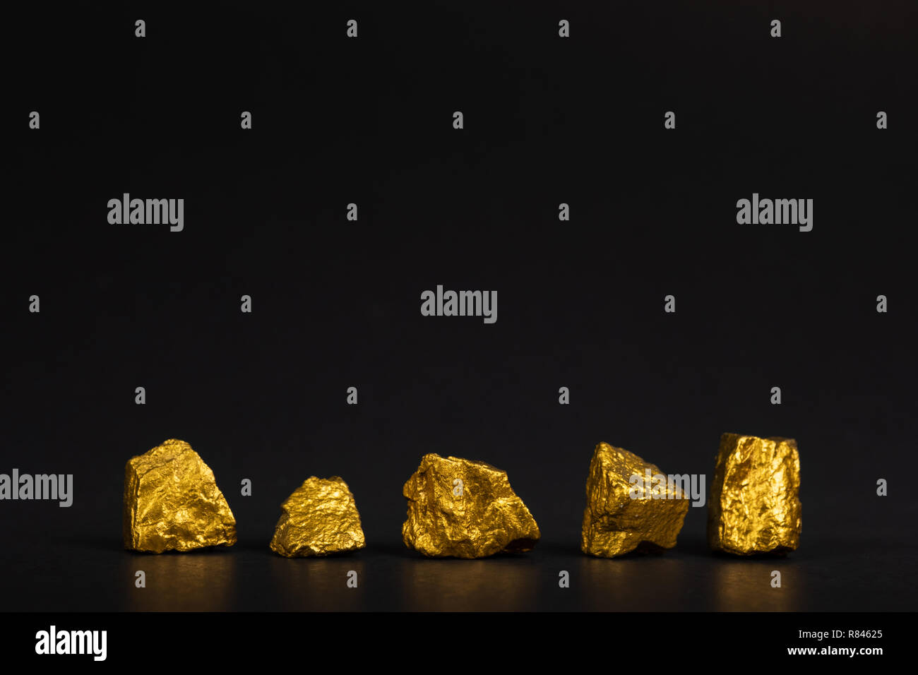 A pile of gold nuggets or gold ore on black background, precious stone ...