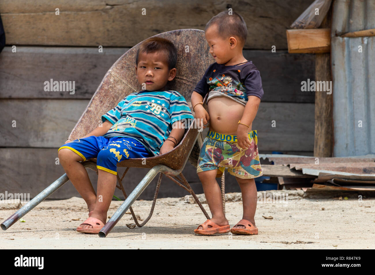 Thakhek, Laos - April 20, 2018: Local boys chilling in a stroller in a ... Thakhek, Laos - April 20, 2018: Local boys chilling in a stroller in a ...