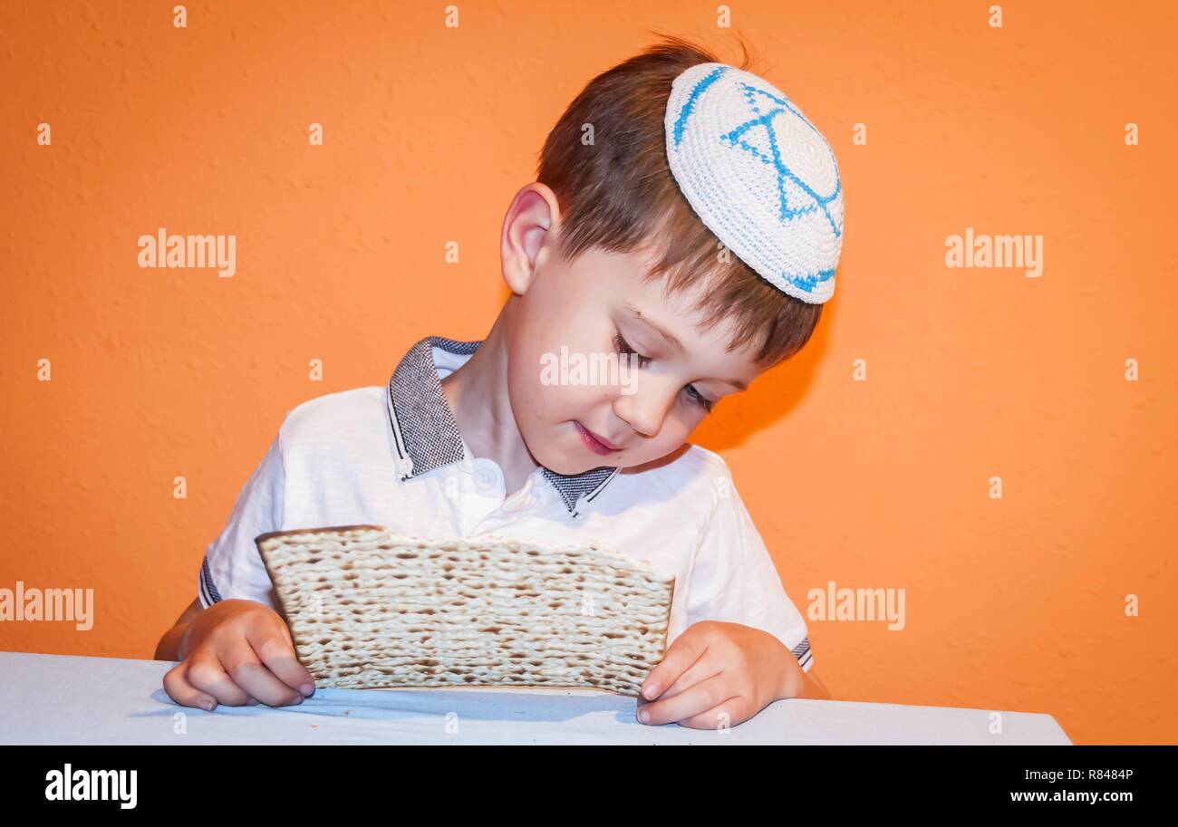 Cute Caucasian Jewish child with a kippah on his head touching the ...