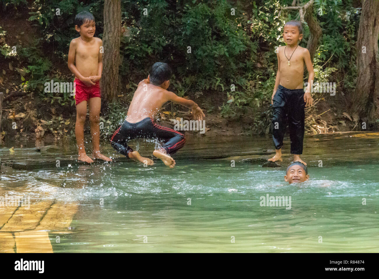 Thakhek, Laos - April 20, 2018: Local children jumping in the water and ... Thakhek, Laos - April 20, 2018: Local children jumping in the water and ...