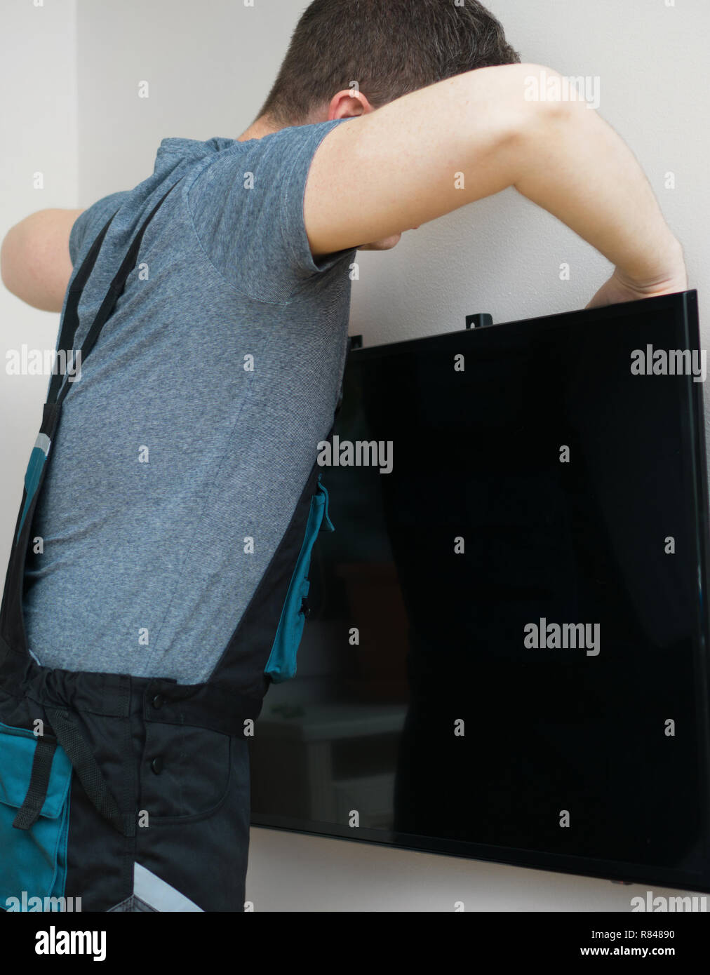 Man mounting new TV on the wall Stock Photo - Alamy