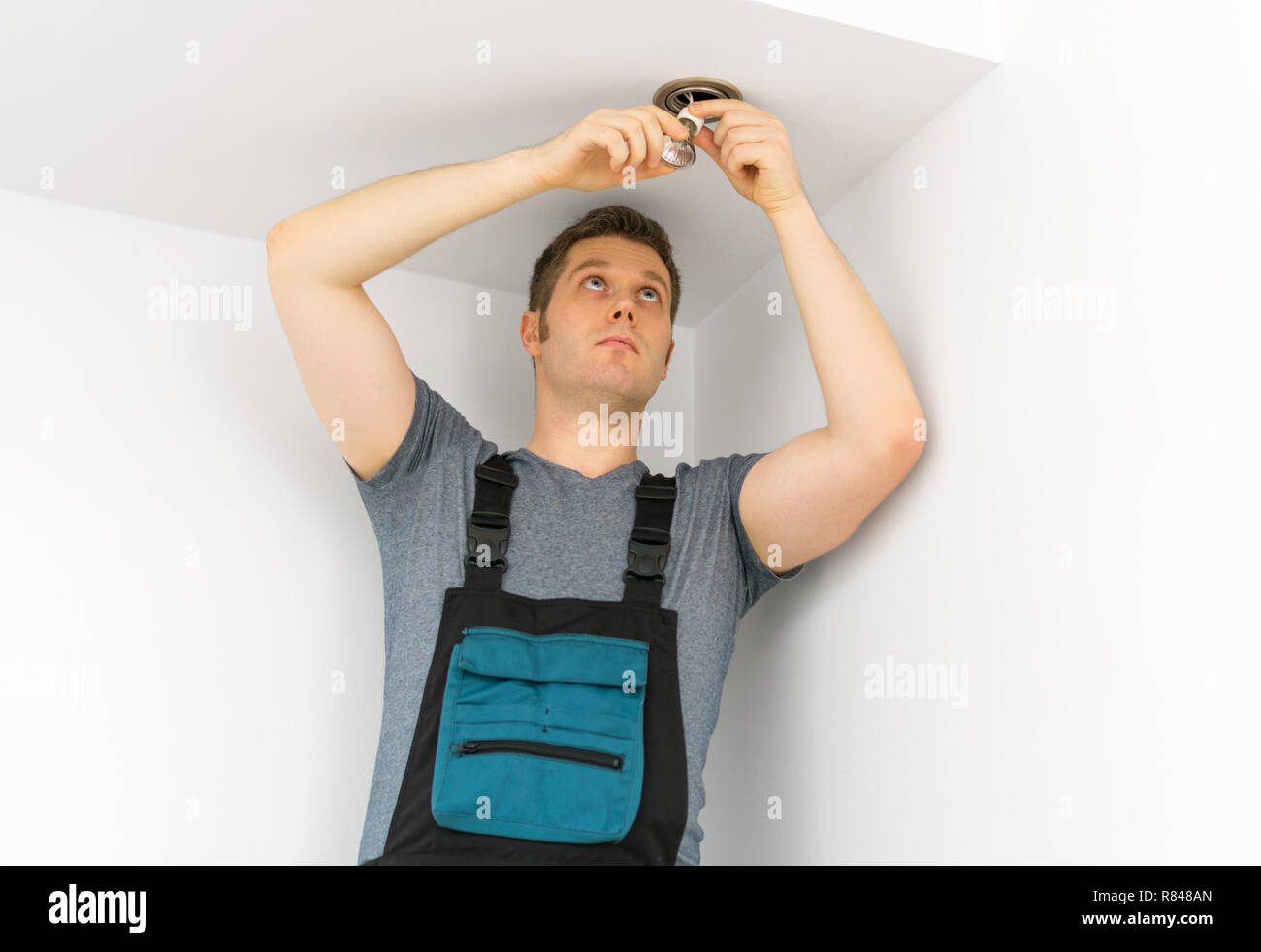 Certified electrician installing light bulb Stock Photo - Alamy