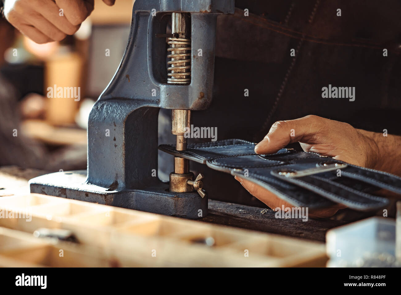 Man works in carpentry workshop. He fixes wooden handle in vice ...