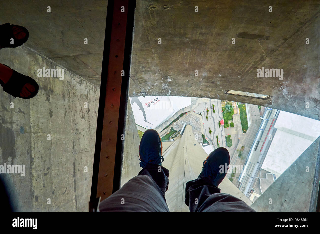 Man's feet on the glass floor of the CN tower, 350 meters above ground ...