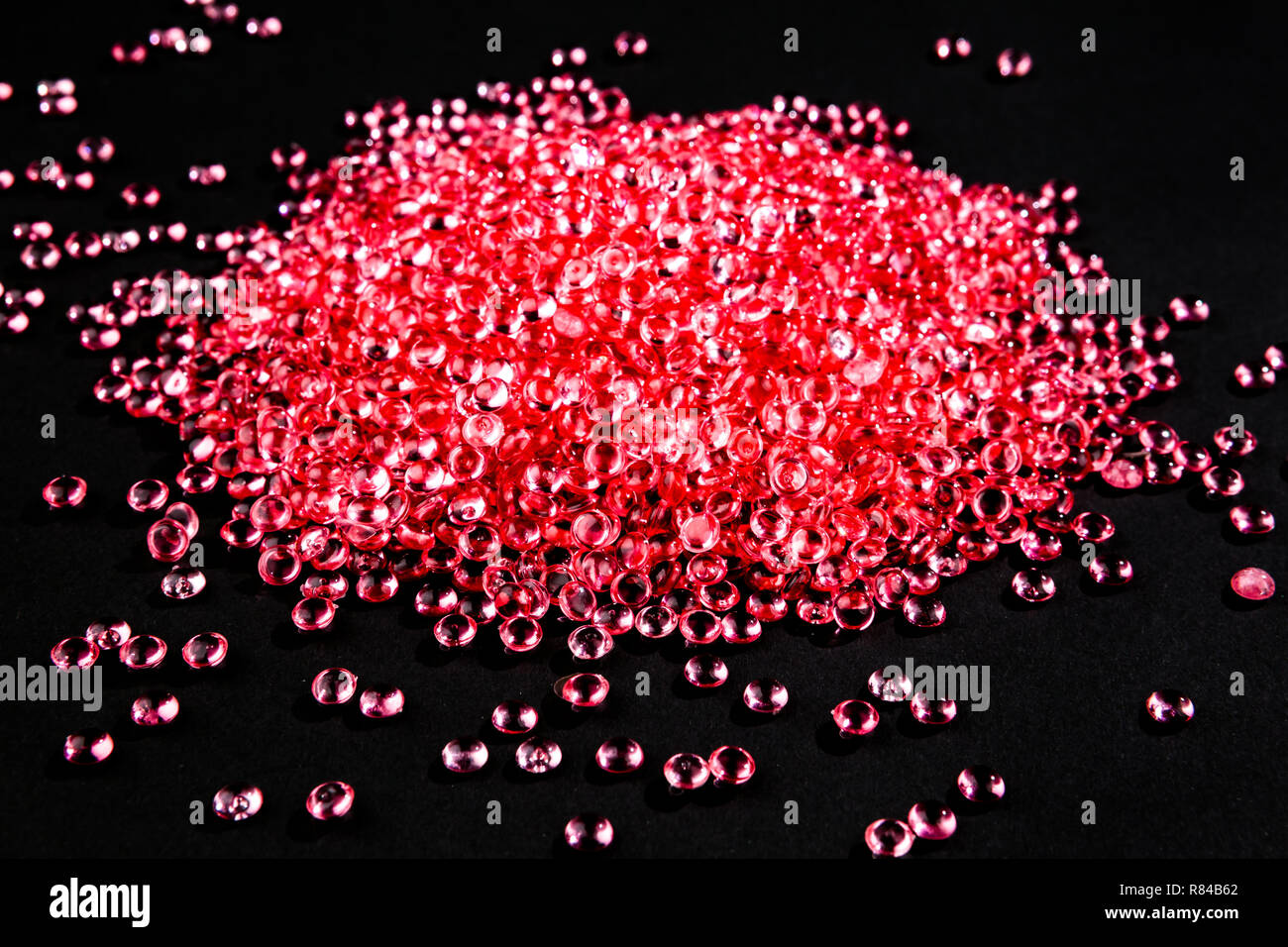 Pile of red round plastic beads on dark background Stock Photo - Alamy