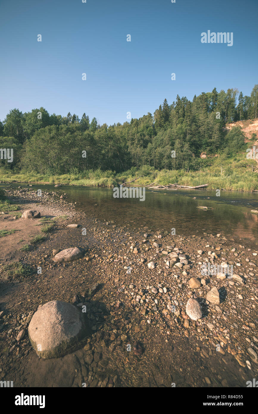 water stream in river of Amata in Latvia with sandstone cliffs, green ...