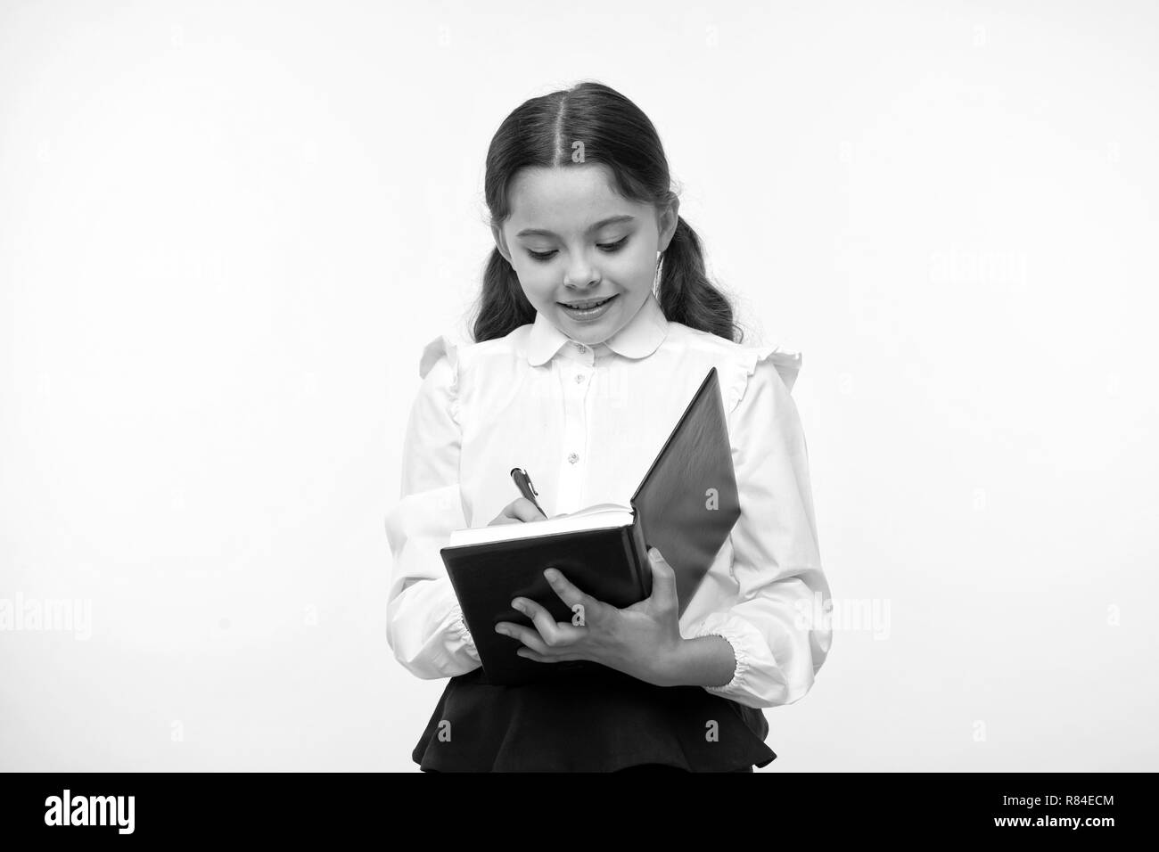 Schoolgirl write in notebook on yellow background. Girl in school ...